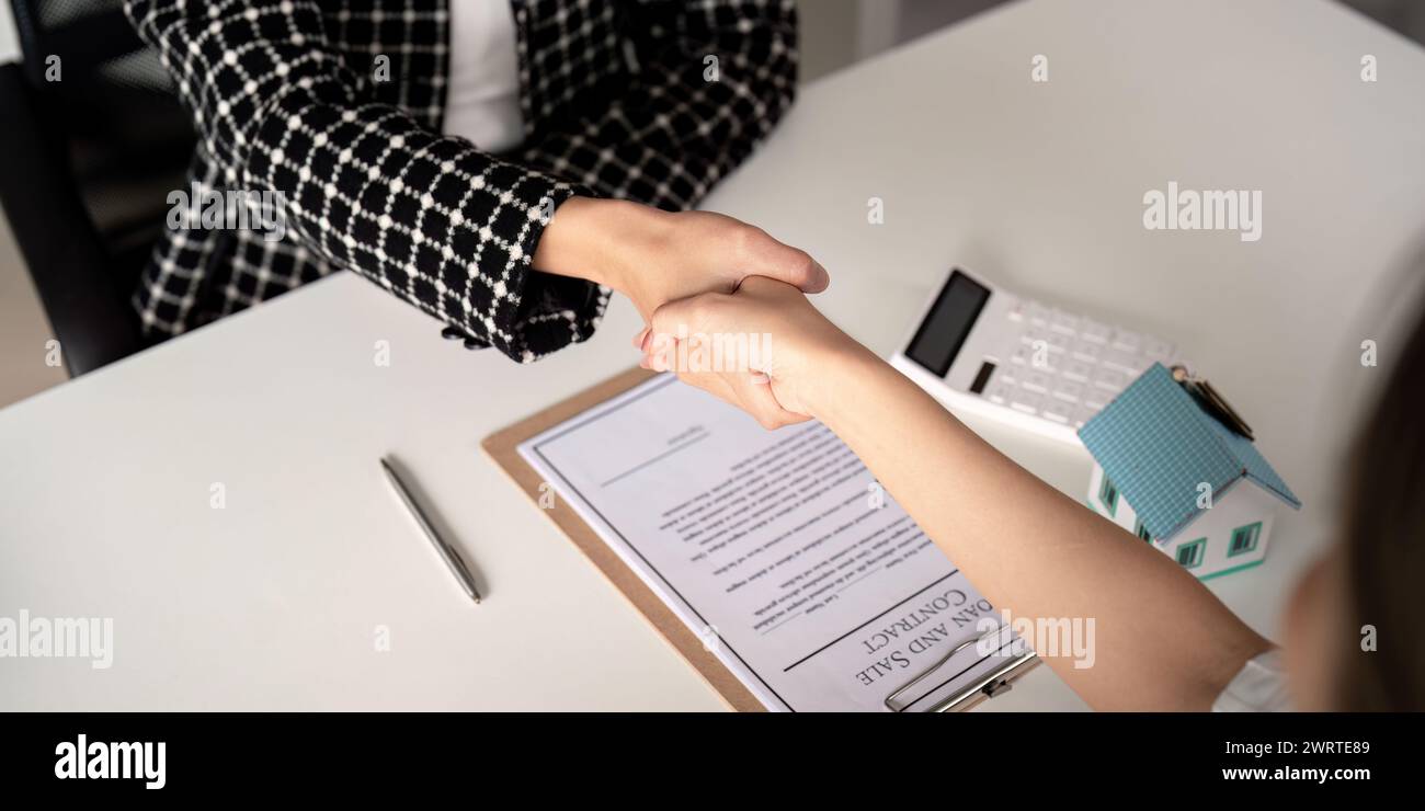 Real estate agents and customers shake hands to congratulate on signing ...