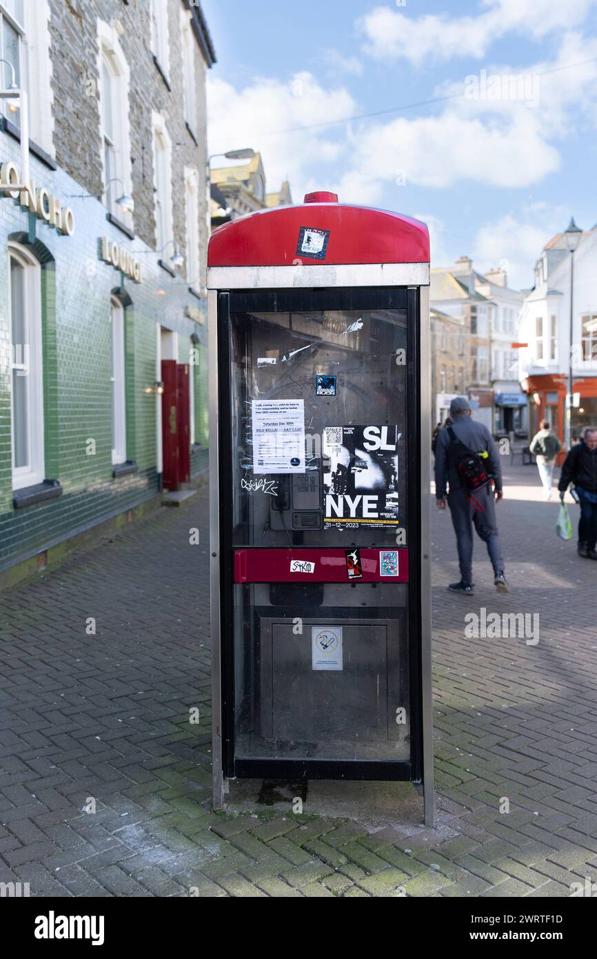 An ugly public telephone box covered in stickers in Newquay town centre ...