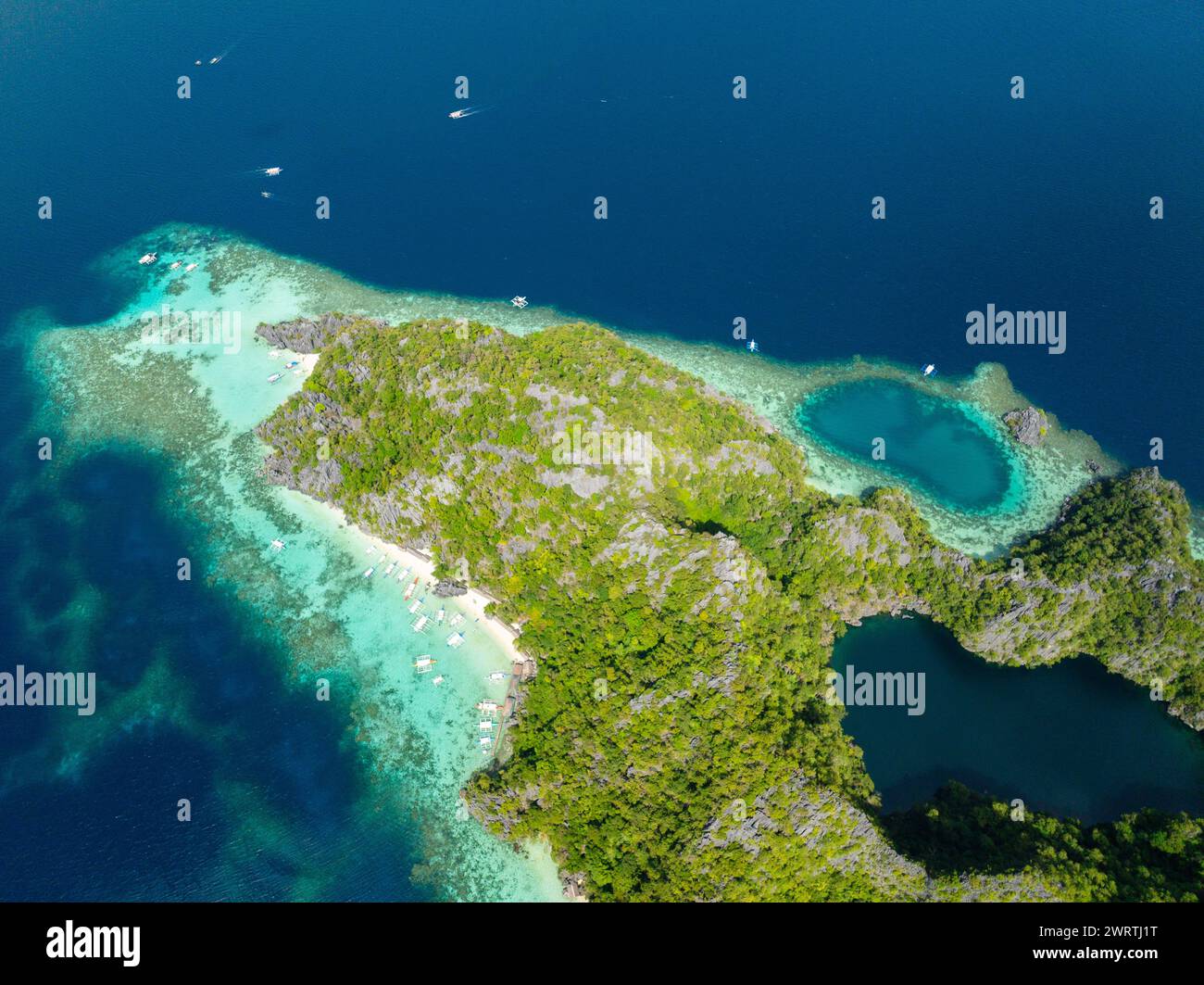 Banul Beach with white sands and boats. Black Lake in Coron, Palawan ...