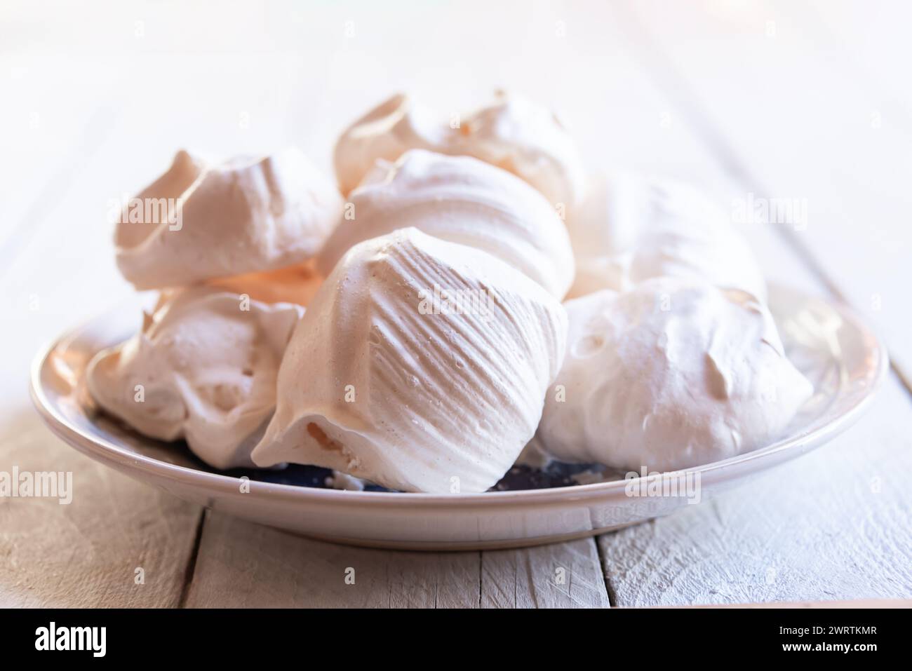 Homemade meringues on plate, white background Stock Photo - Alamy