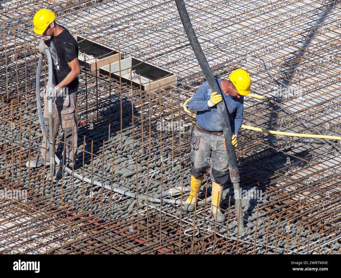 Construction workers backfilling concrete on a building site, Berlin ...