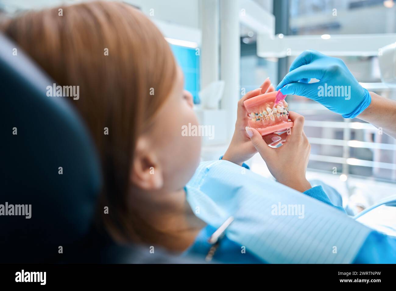 Young patient examines a dummy jaw with braces Stock Photo - Alamy