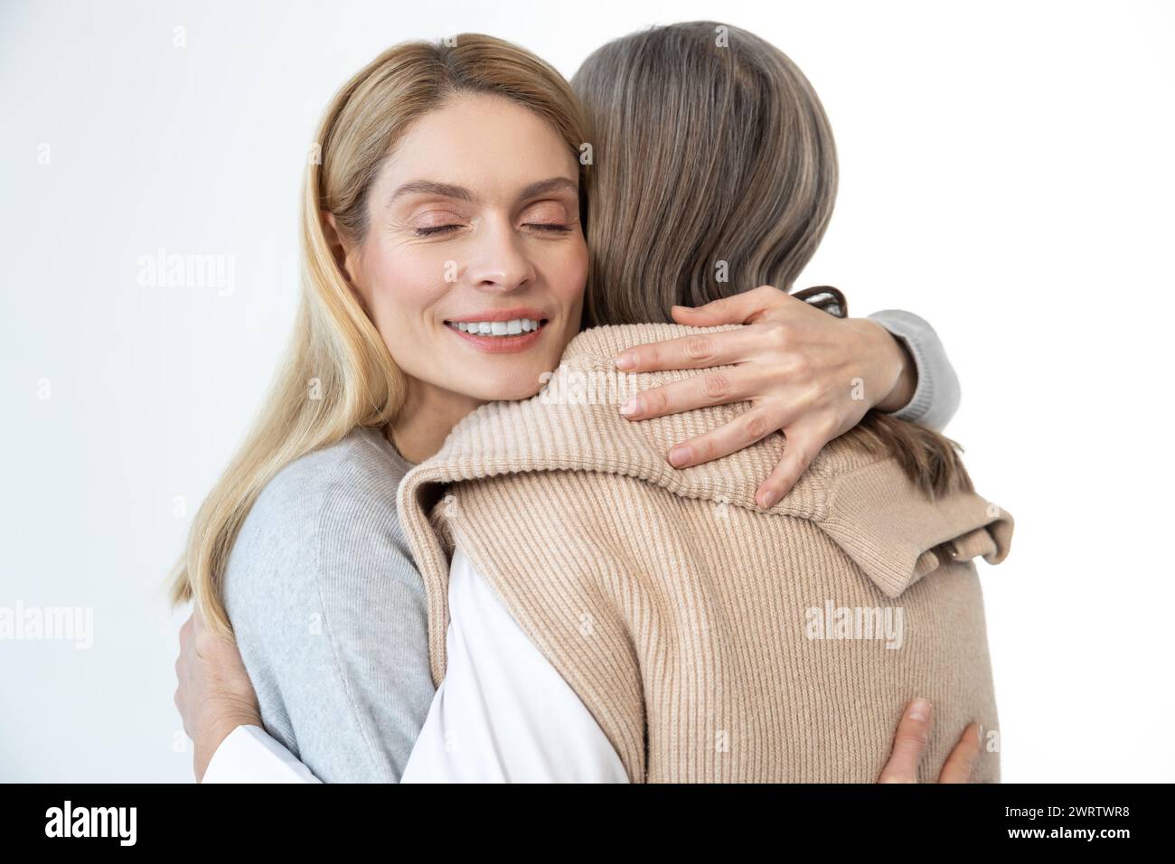 Blonde woman hugging her mom and looking happy Stock Photo - Alamy