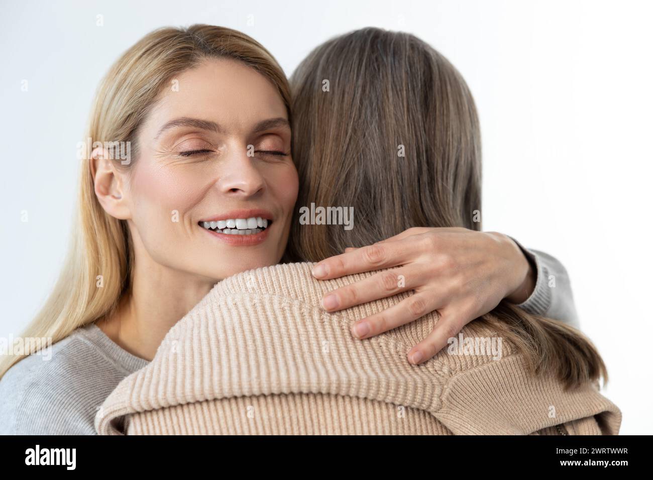 Blonde woman hugging her mom and looking happy Stock Photo - Alamy