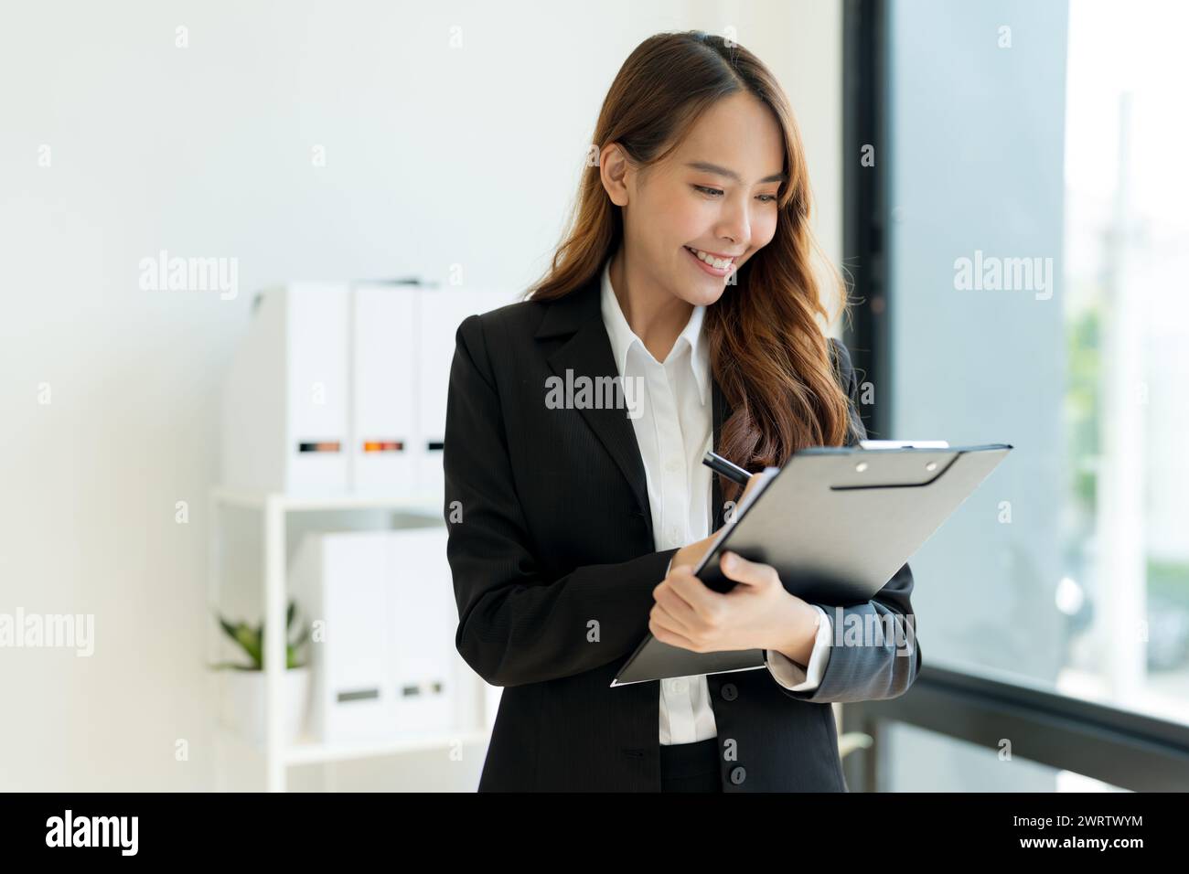 Business woman holding files Inside the modern office with a smiling ...