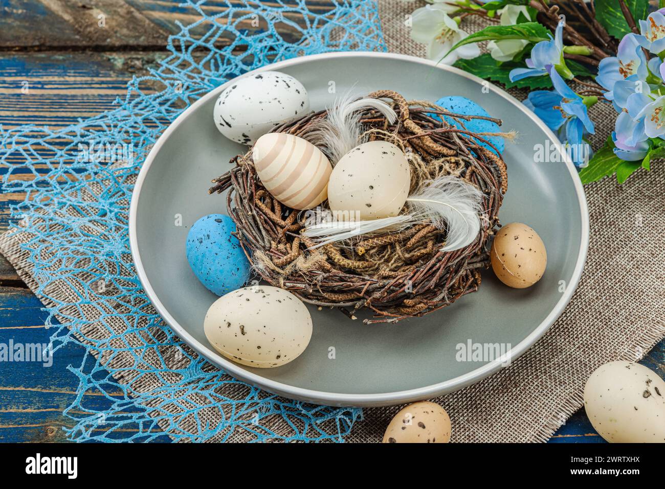 Easter table setting with eggs, bird's nest and blooming branch ...