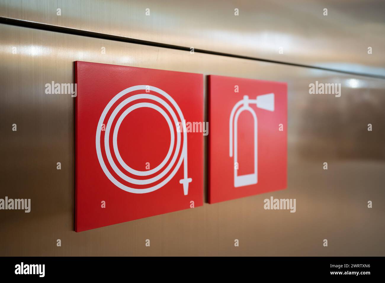 Fire Hose and fire extinguisher signs on the wall Stock Photo - Alamy