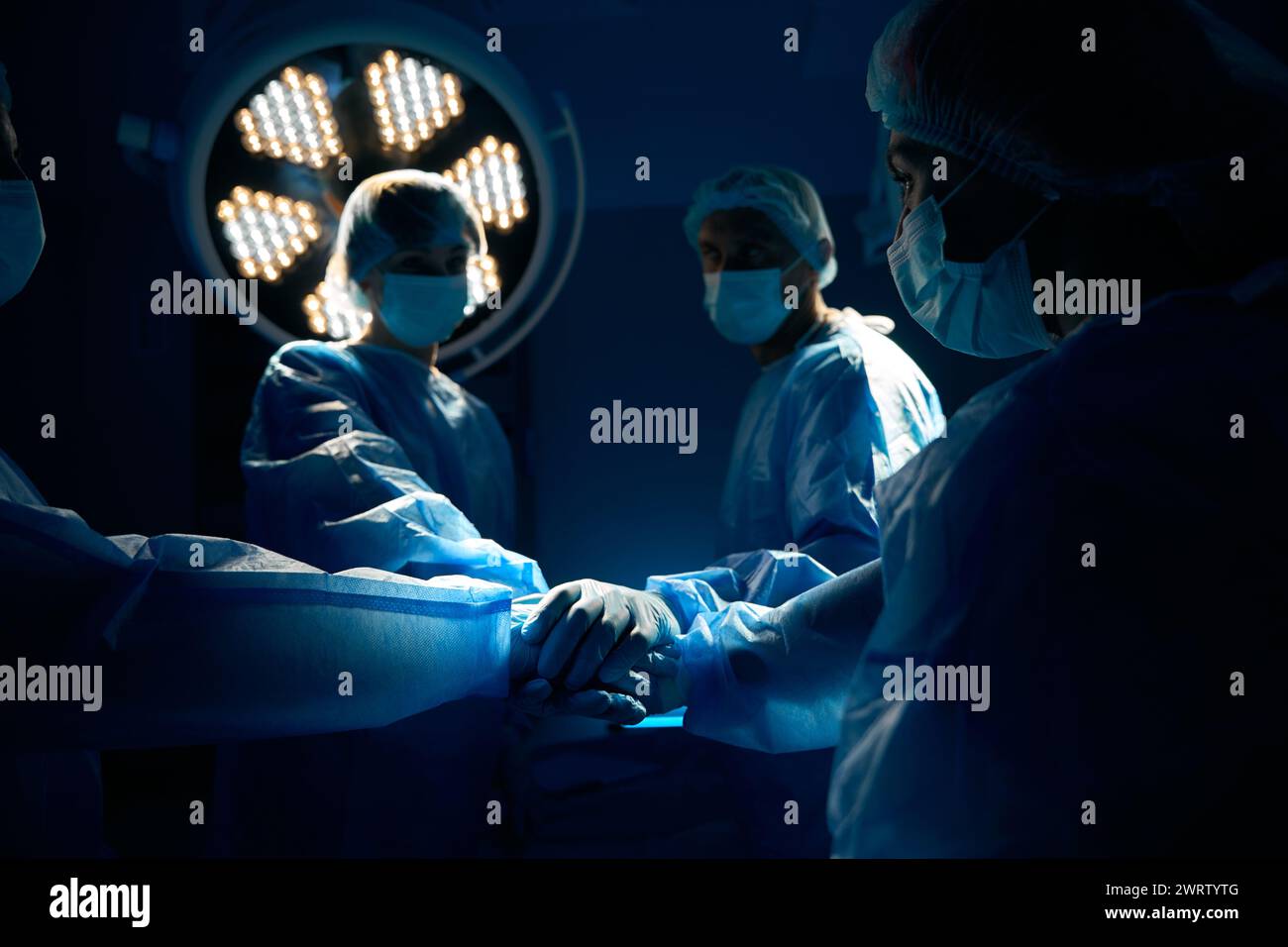 Talented doctors holding hands together before the surgery Stock Photo ...