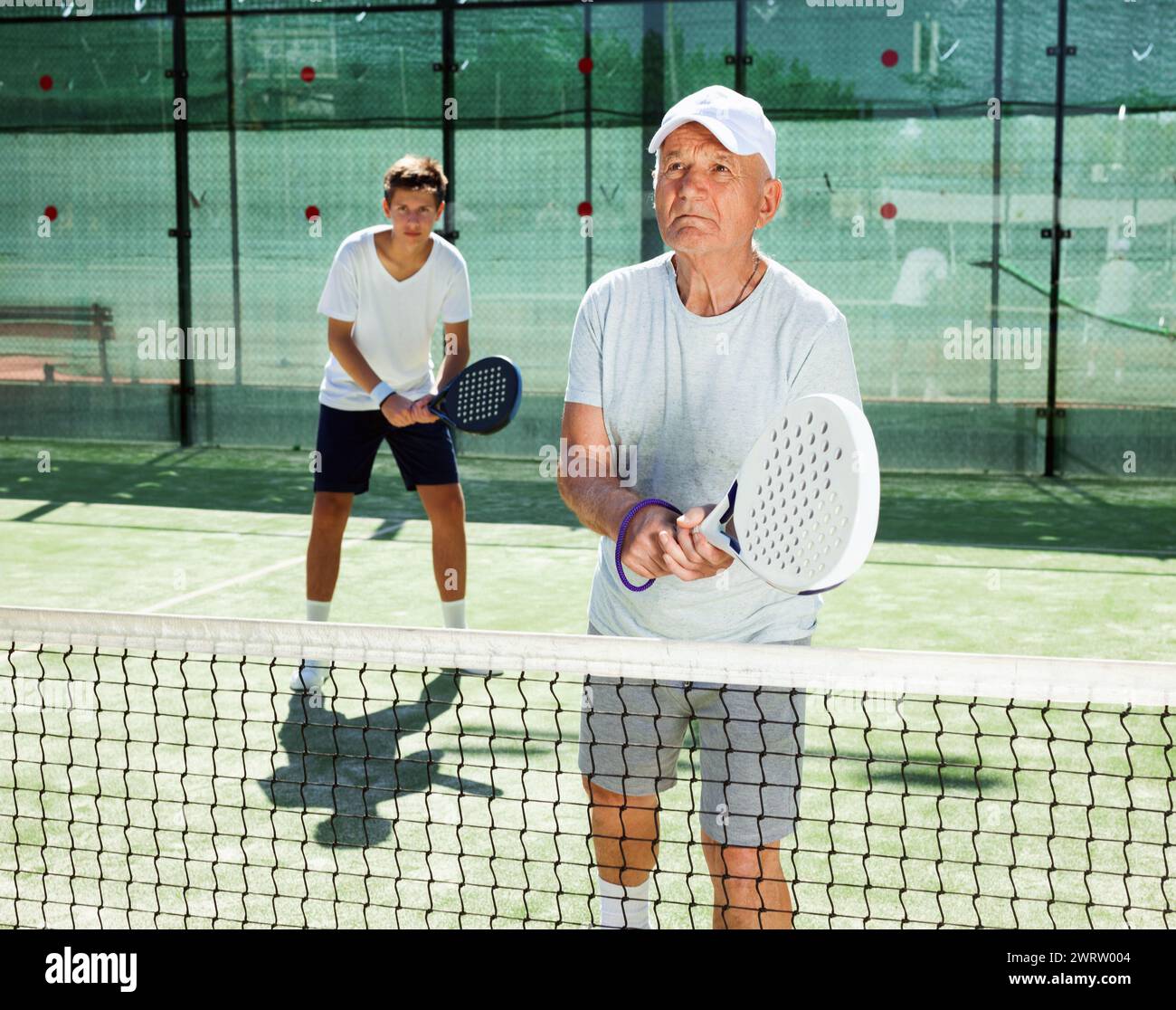 Padel players of different generations playing padel court Stock Photo ...