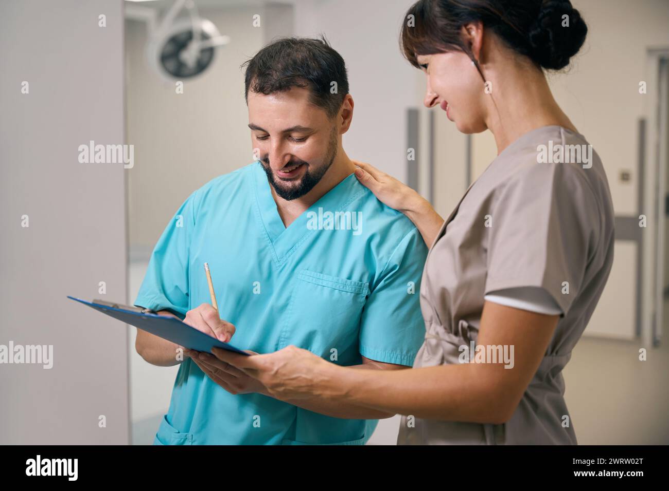 Doctor and nurse standing signing documents Stock Photo - Alamy