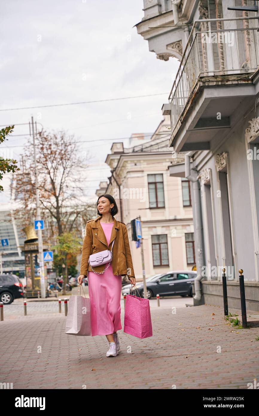 Pretty female walking in downtown looking around Stock Photo - Alamy