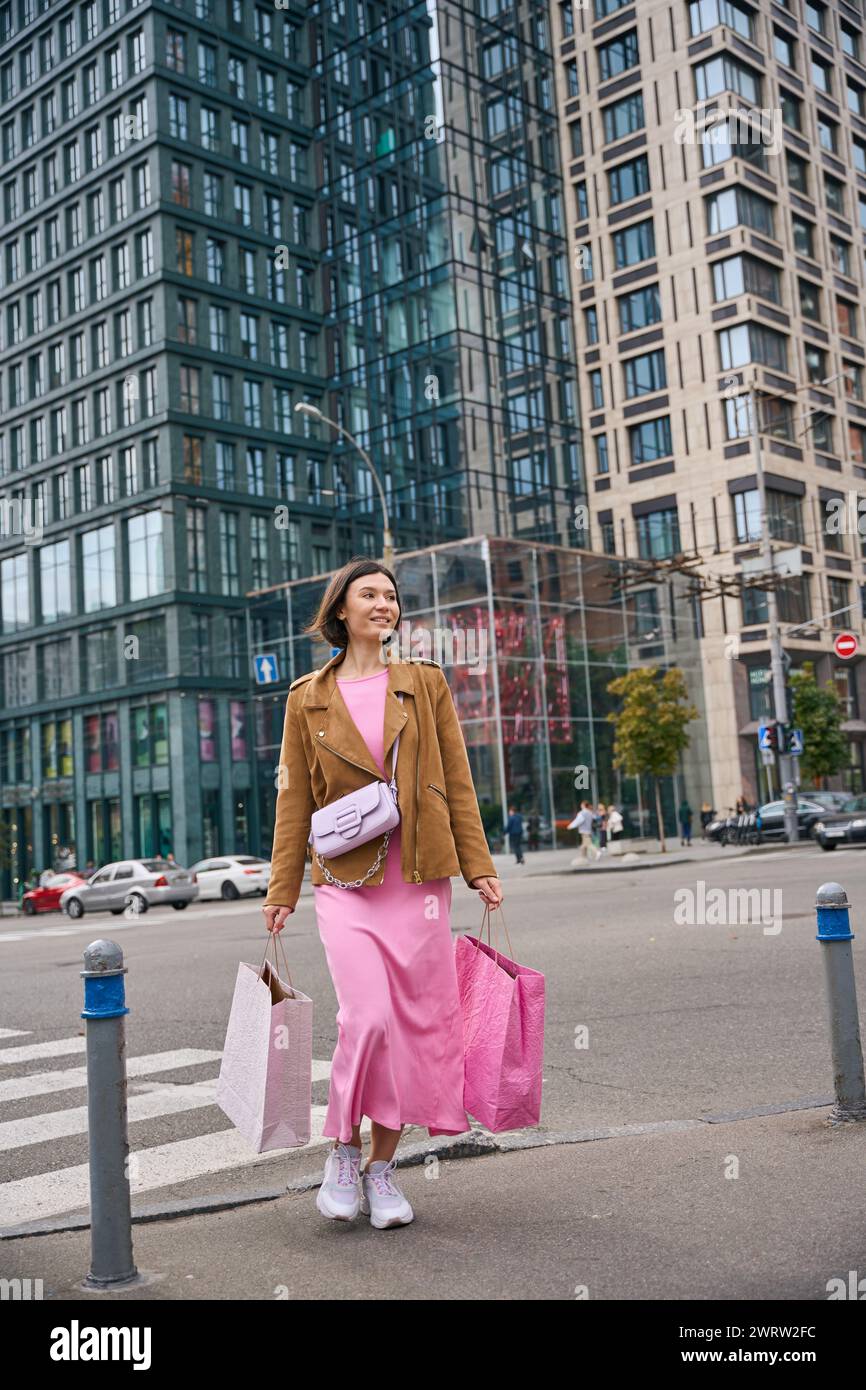 Happy female walking across street and looking around Stock Photo - Alamy