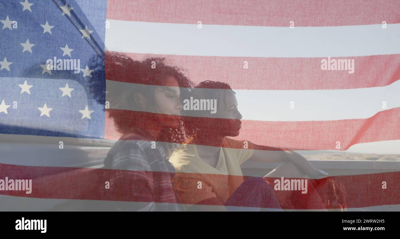 Image of American flag waving over biracial couple on beach by seaside ...