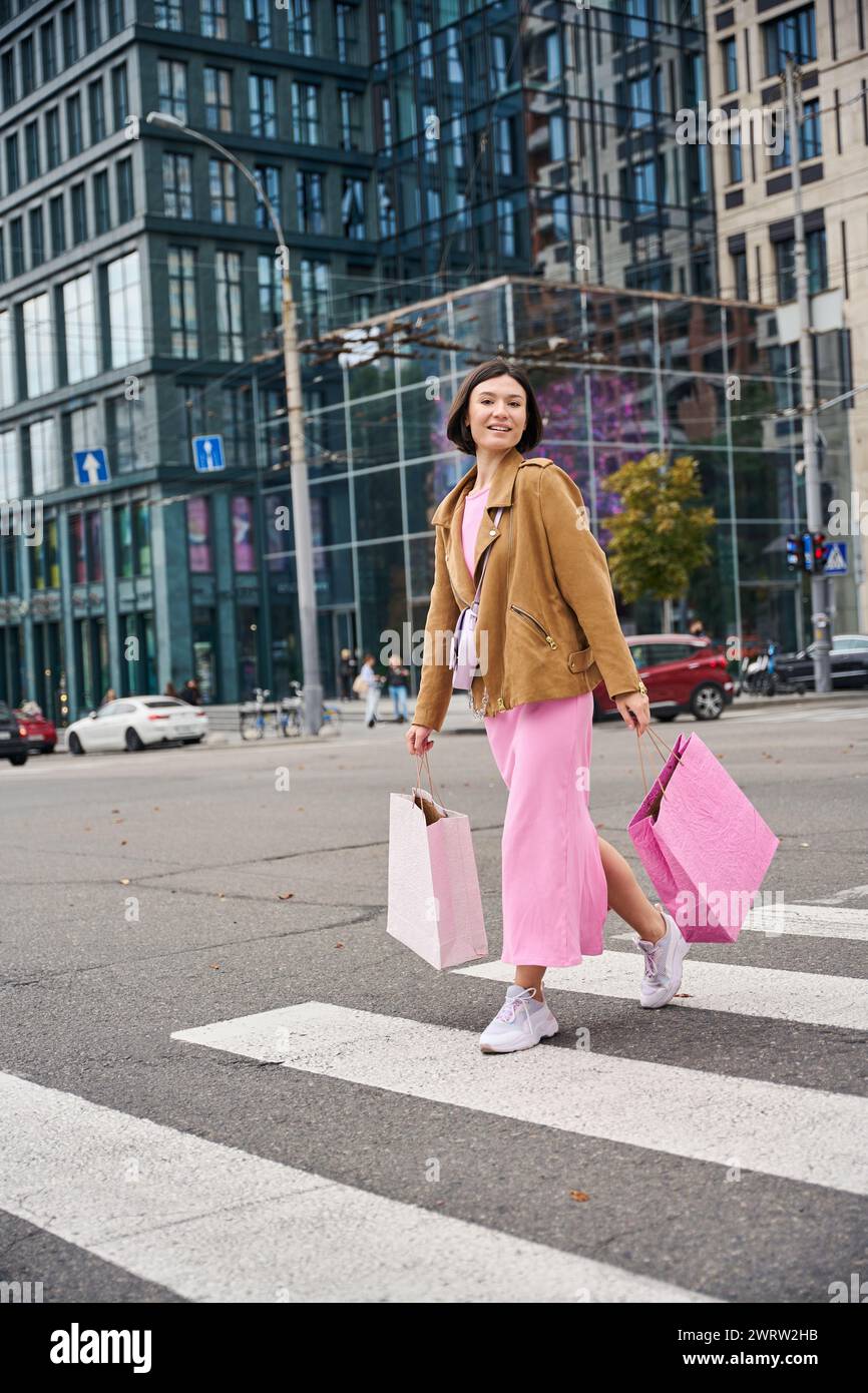 Pretty woman in pink dress crossing street Stock Photo - Alamy