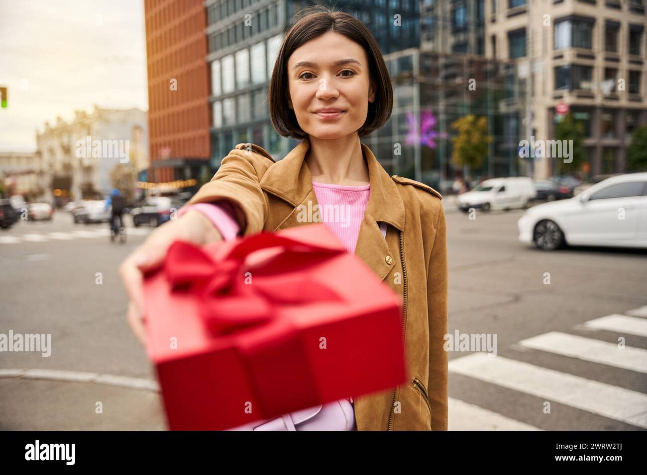 Happy pretty lady giving red present box Stock Photo - Alamy