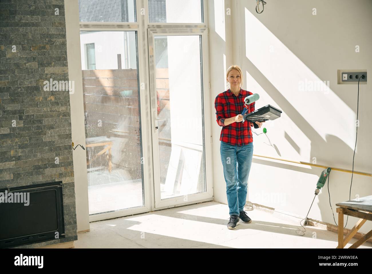 Full length photo of joyful woman standing in uncompleted room while ...