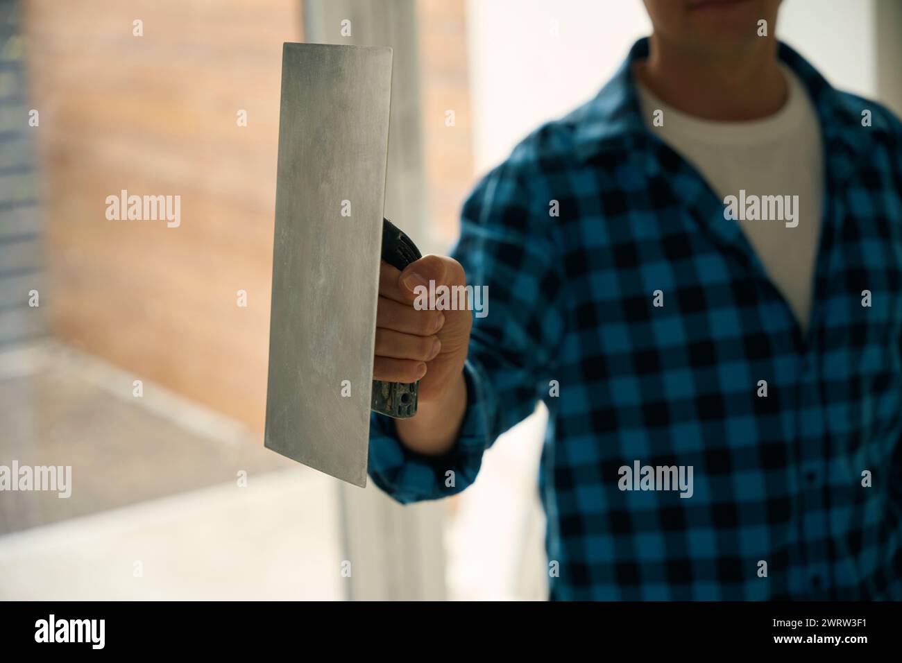 Close up photo of male hand holding float trowel while man standing ...