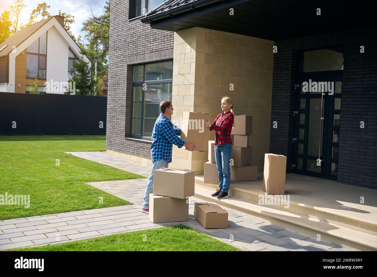 Full length photo of husband giving box to smiling wife who standing ...