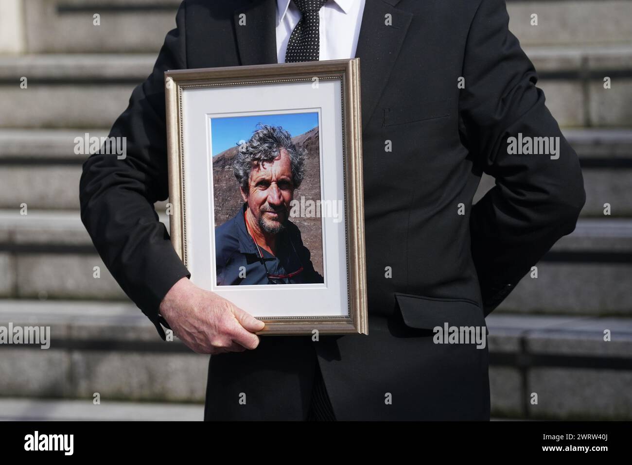 A man holds a photograph of Charlie Bird at a service at Mansion House ...