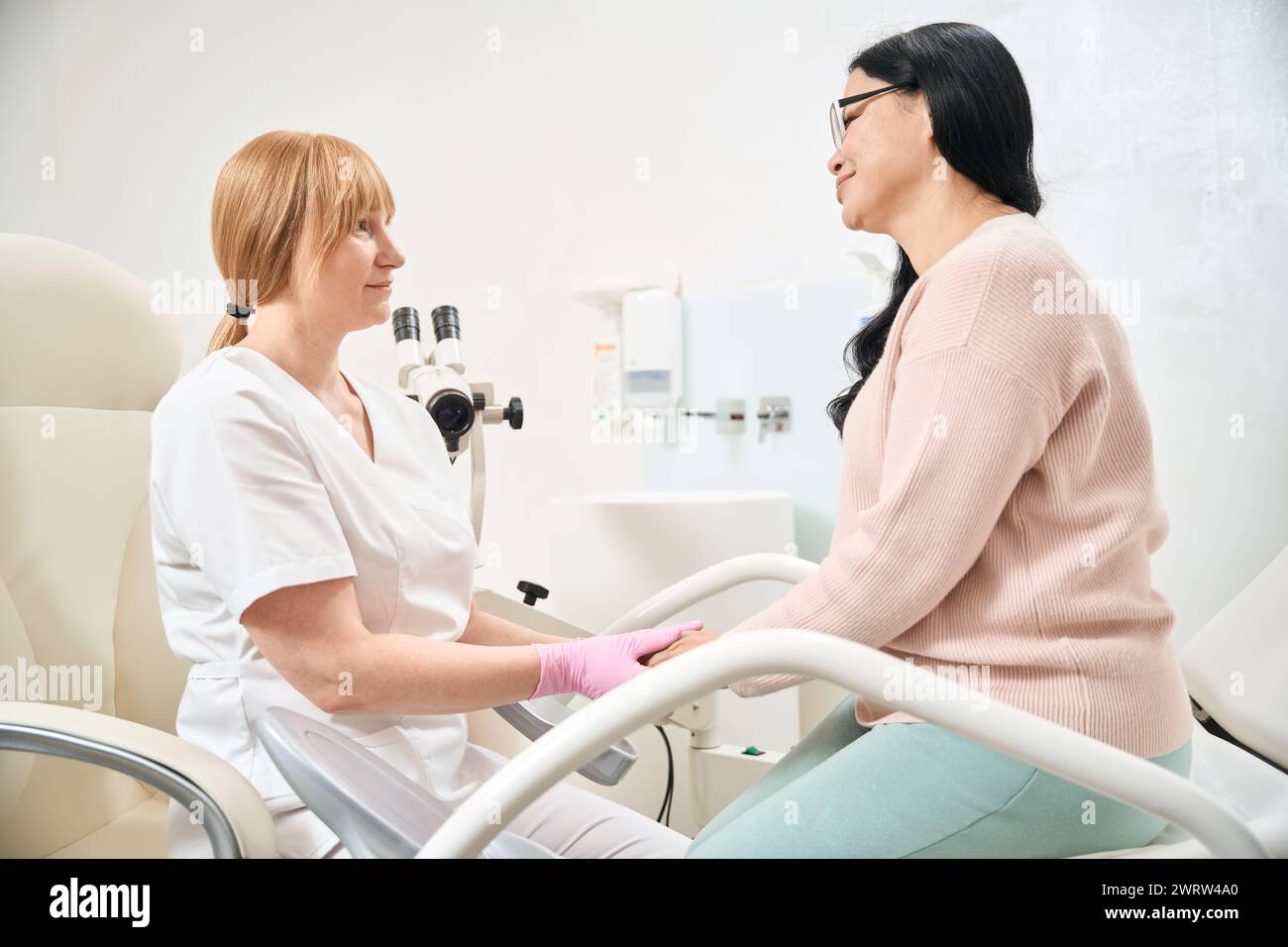 Woman gynecologist talking to patient after examination on medical chair Stock Photo - Alamy