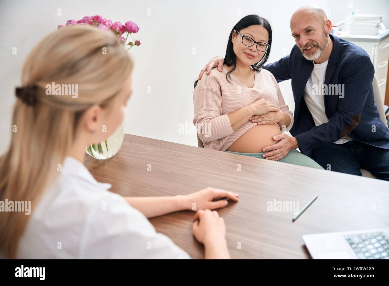 Adult family couple visiting obstetrician office to talk about third ...