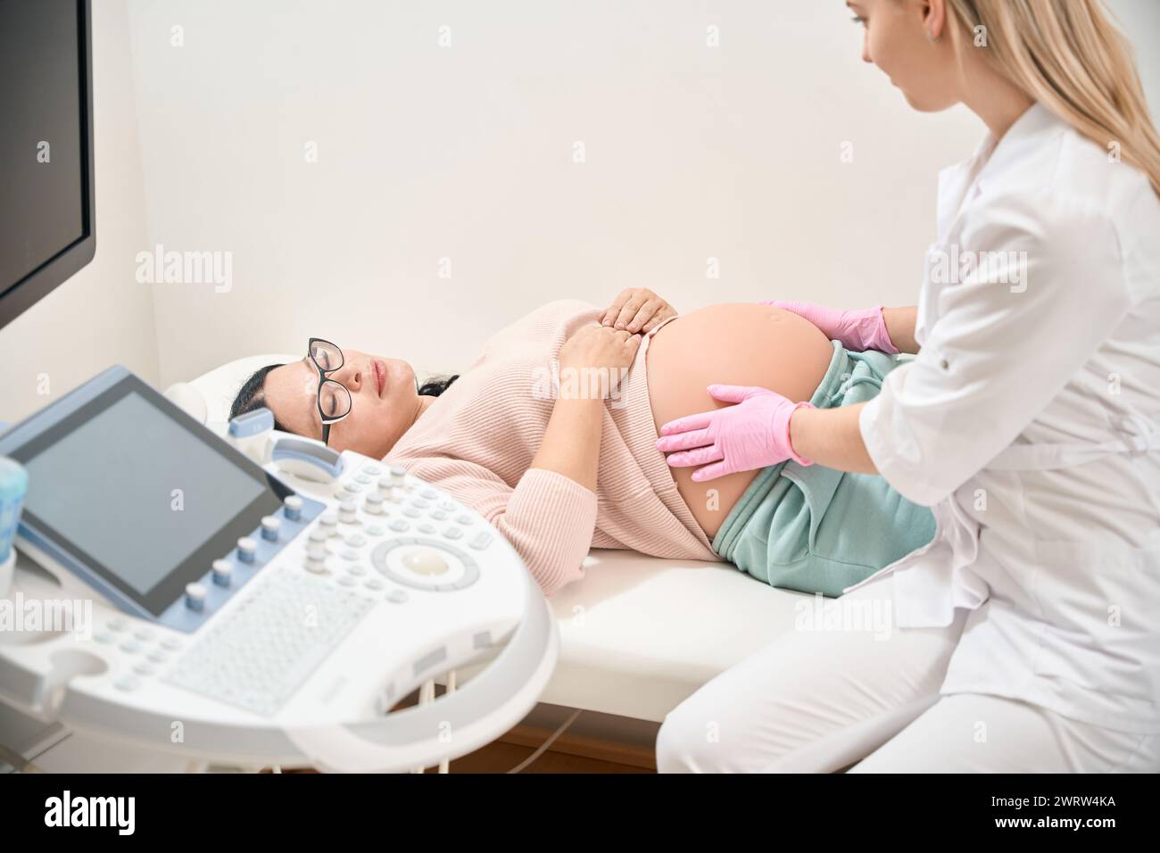 Woman gynecologist going to change presentation of baby inside womb ...
