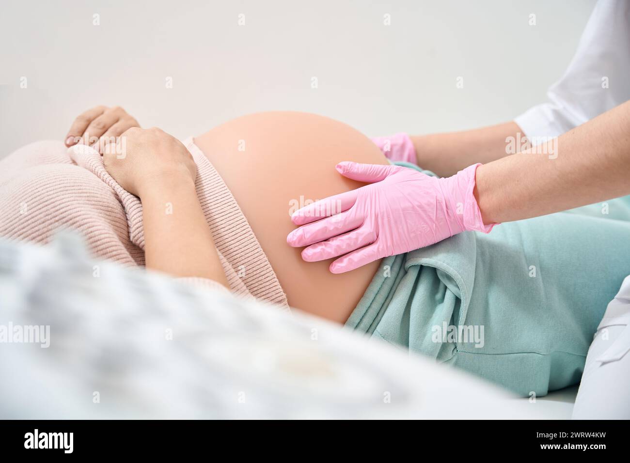 Qualified gynecologist-obstetrician in medical gloves examining belly ... Qualified gynecologist-obstetrician in medical gloves examining belly ...