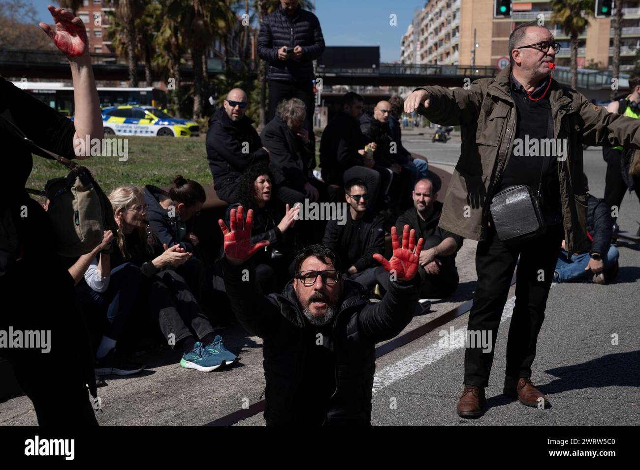 Demonstrators sit on the ground during a rally called by trade unions ...