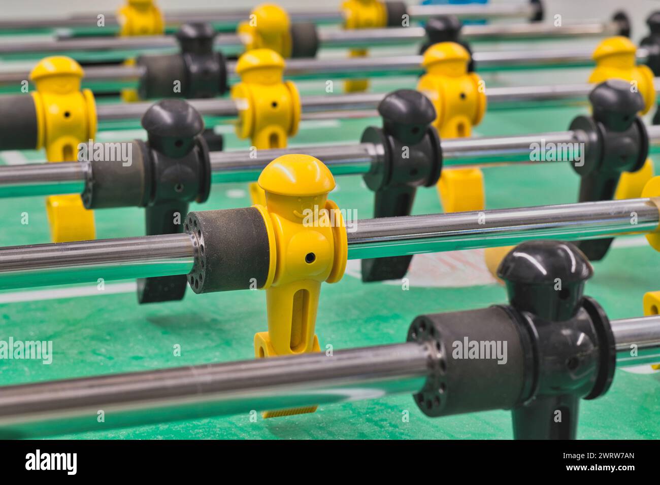 Foosball table game with plastic figures and metal rods low angle view ...
