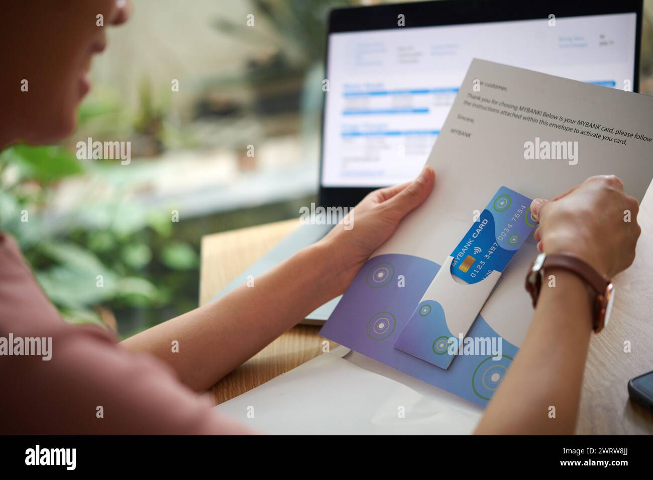 Hands of woman taking credit card out of letter from bank Stock Photo ...