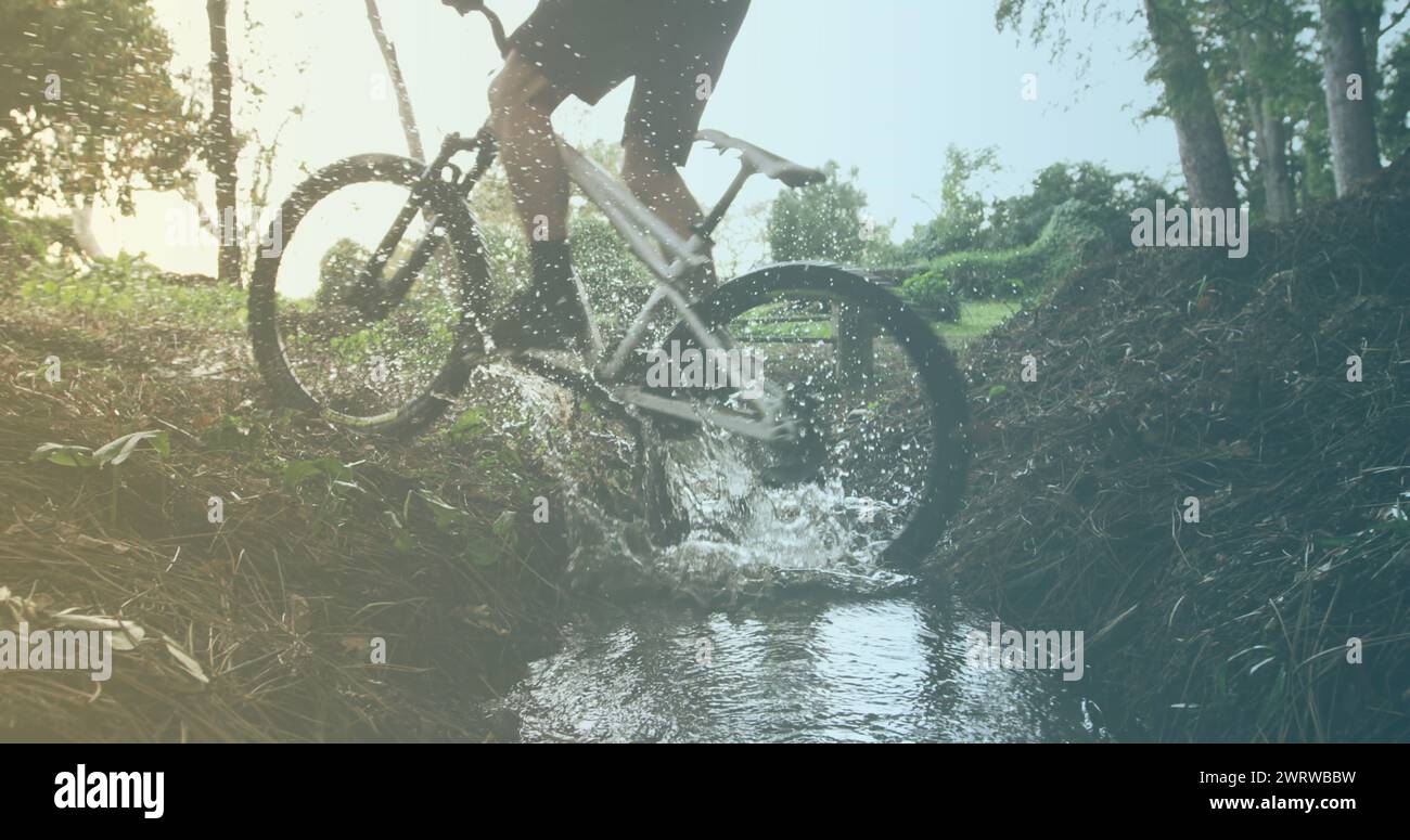 Spots of light against mid section of a man riding a bicycle through ...