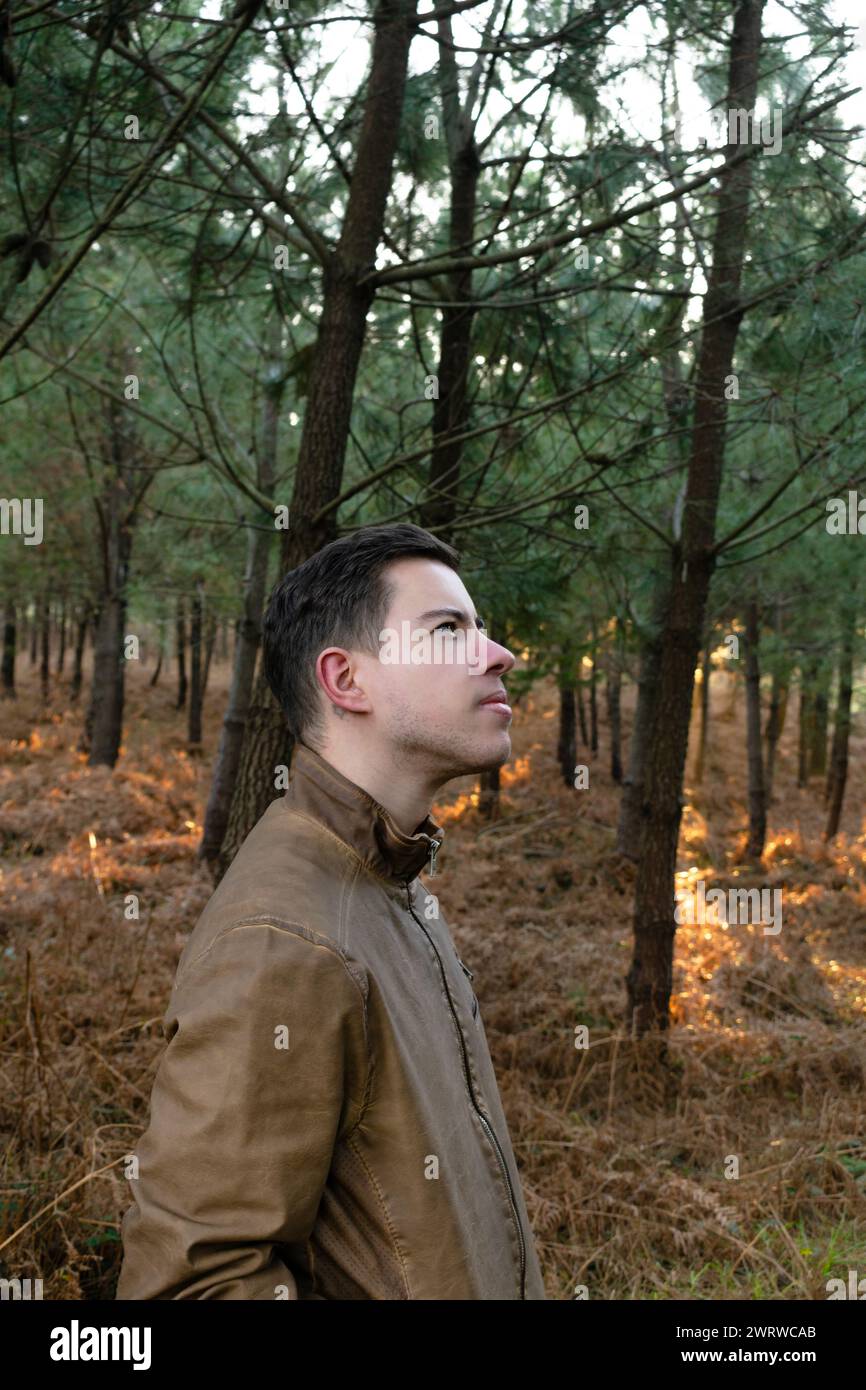 Stock photo of a young man looking around in the forest enjoying nature ...