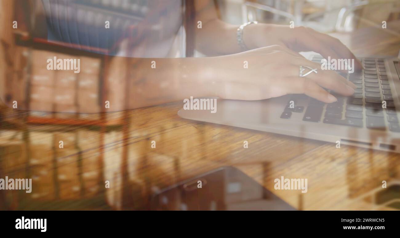 Image of woman typing on computer keyboard with stacks of boxes in ...