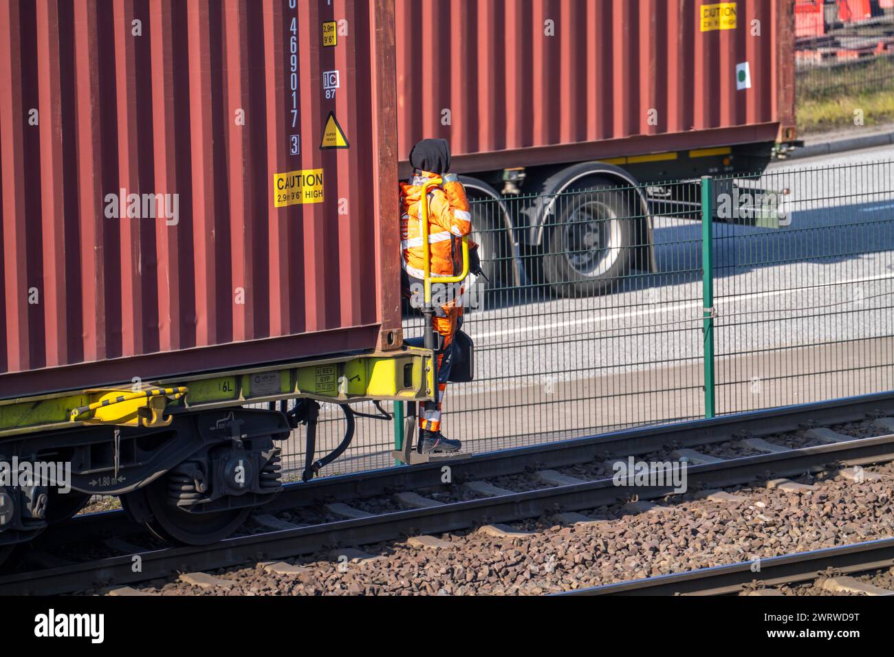 Shunter, railroad employee steers the freight train with containers ...
