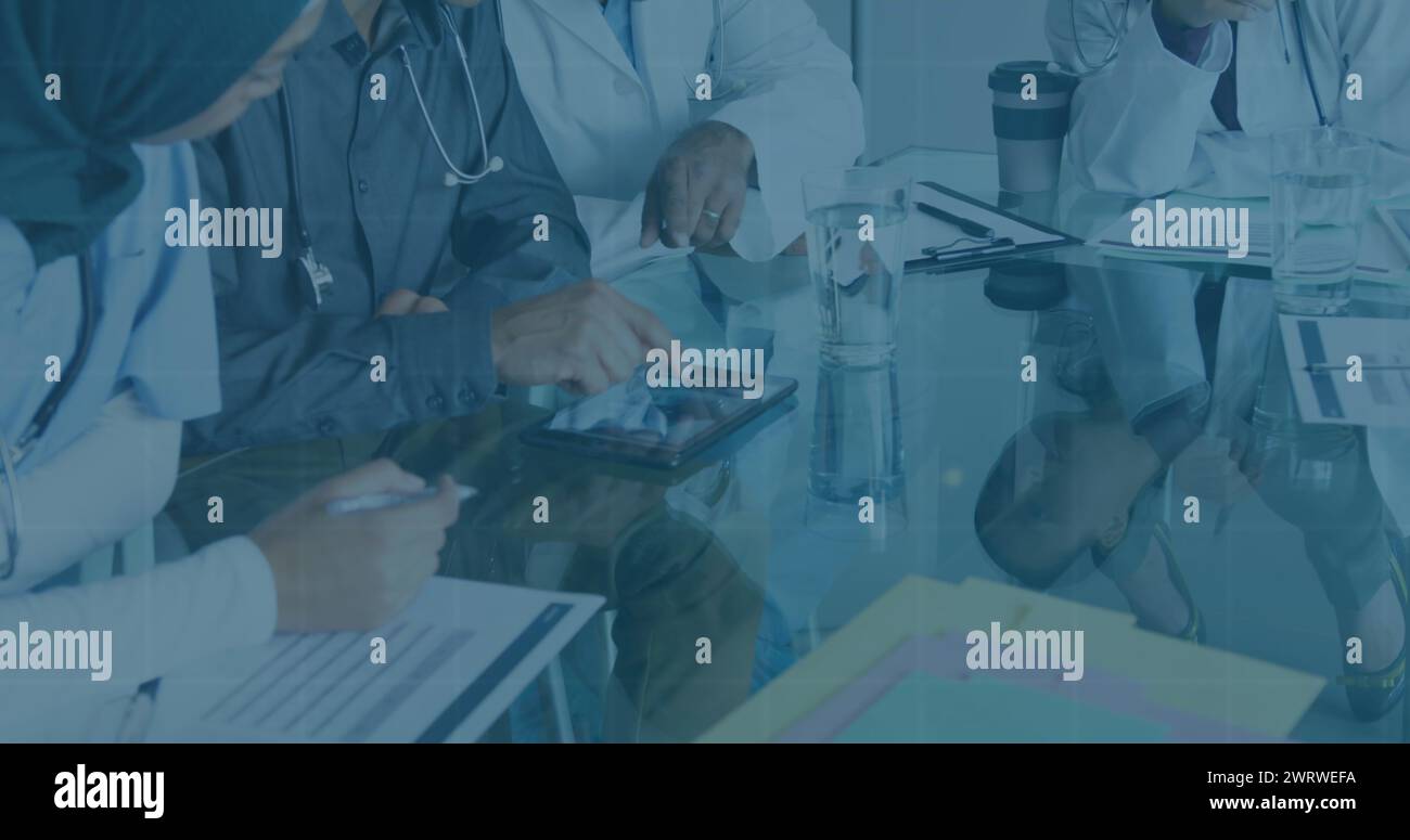 Image of data processing over group of diverse doctors using tablet ...