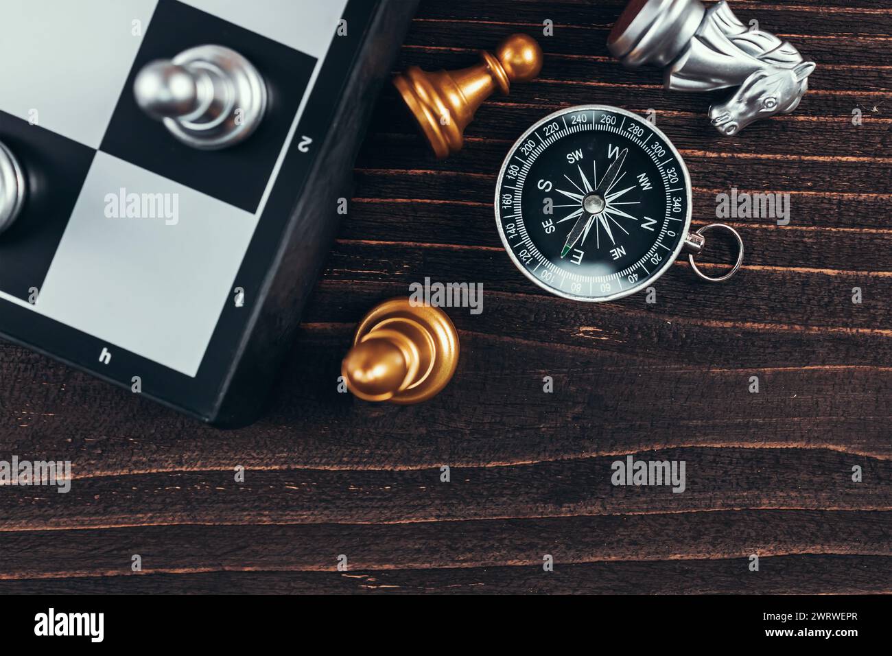 compass and chess piece on chess board game for ideas, challenge, leadership, strategy, business ...