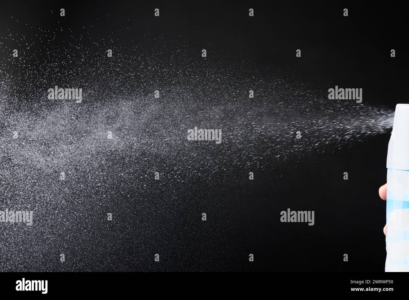 Spray fumes from deodorant close up isolated on black studio background ...