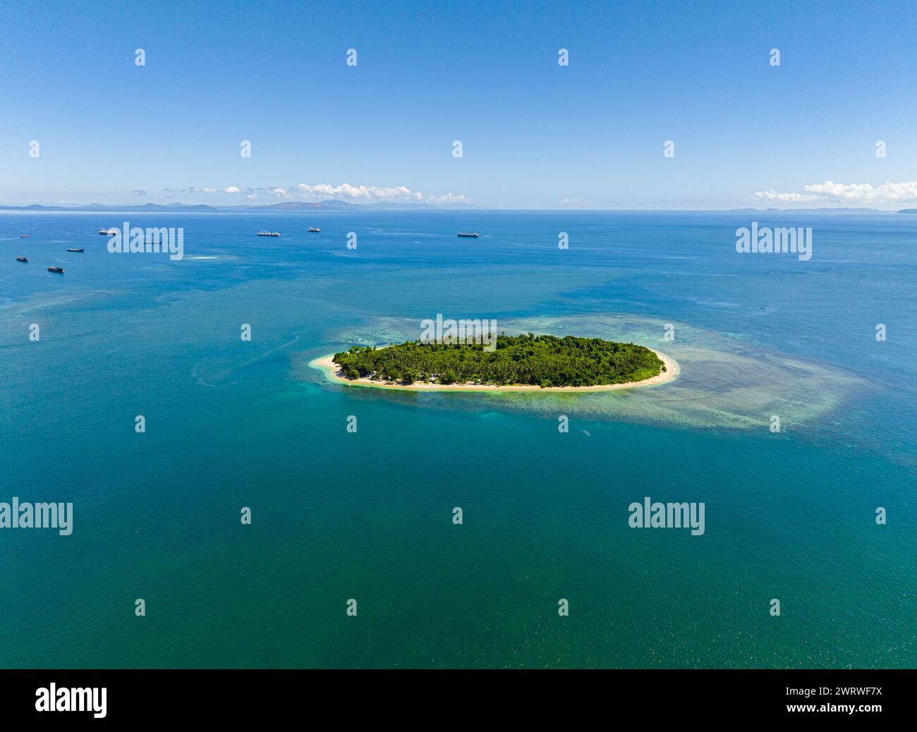 Tropical island surrounded by white sandy beach. Blue sea under the ...