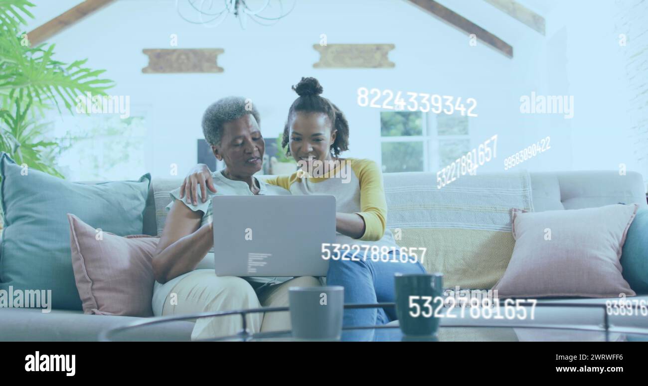Image of numbers changing over african american women using laptop ...