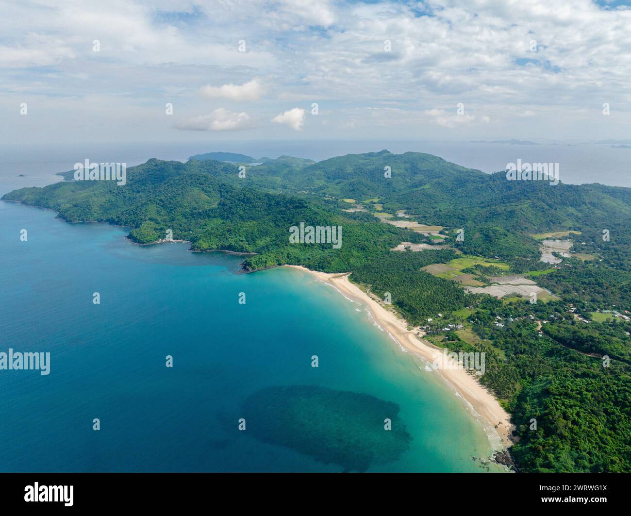 Sandy beach with inshore waves. Dagmay Beach. Blue sky and clouds. El ...
