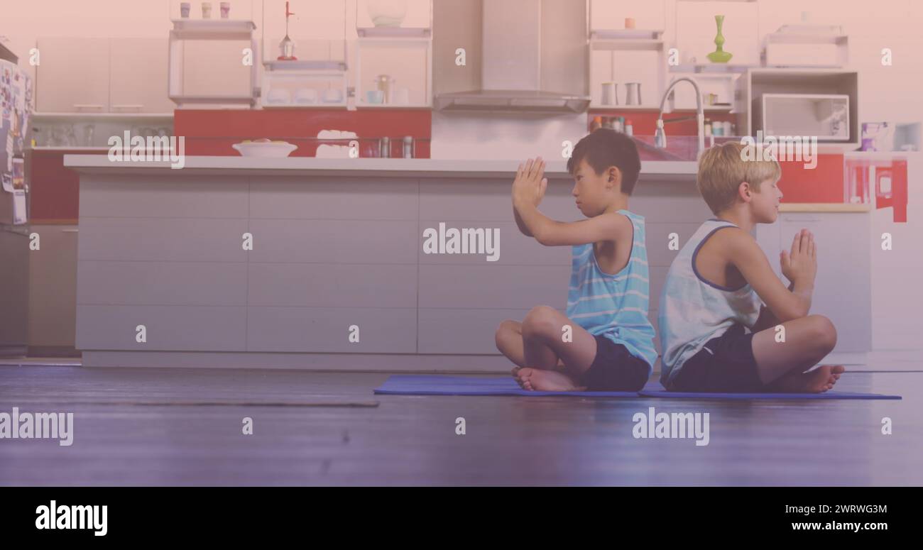 Asian and caucasian brothers performing yoga in the kitchen at home ...