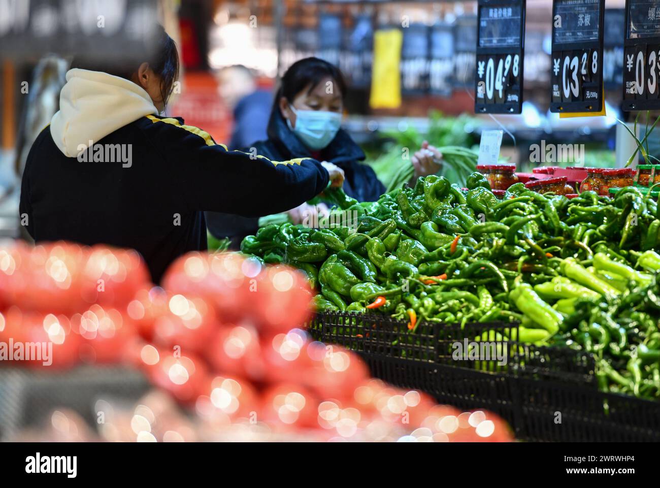 Two women are seen shopping for vegetables at a supermarket. According ...