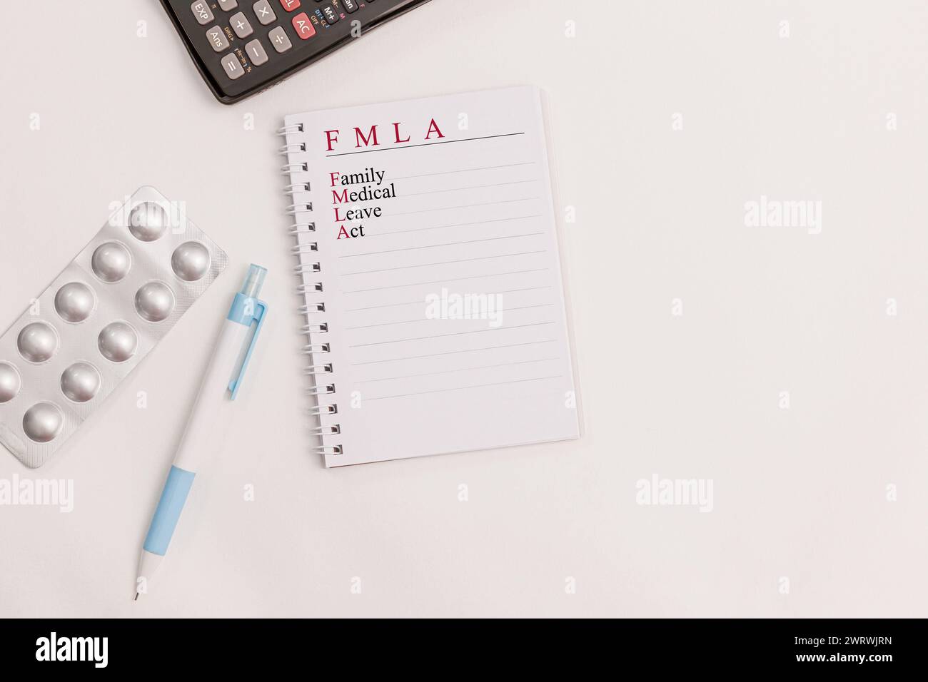 Office scene with notebook with text "FMLA; Family Medical Leave Act ...