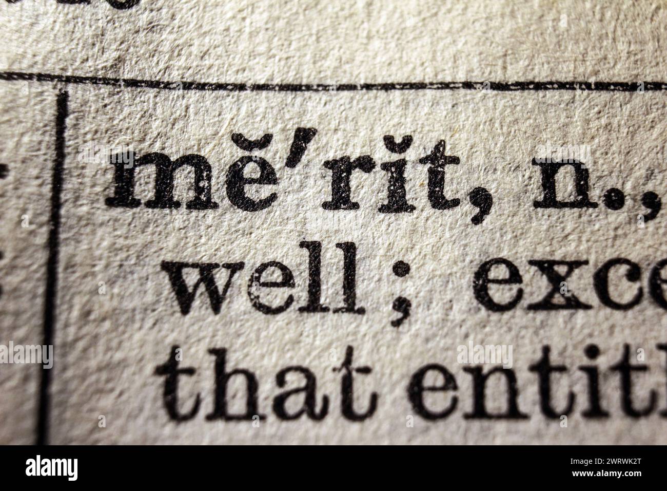 Word merit on dictionary page, macro close-up Stock Photo - Alamy