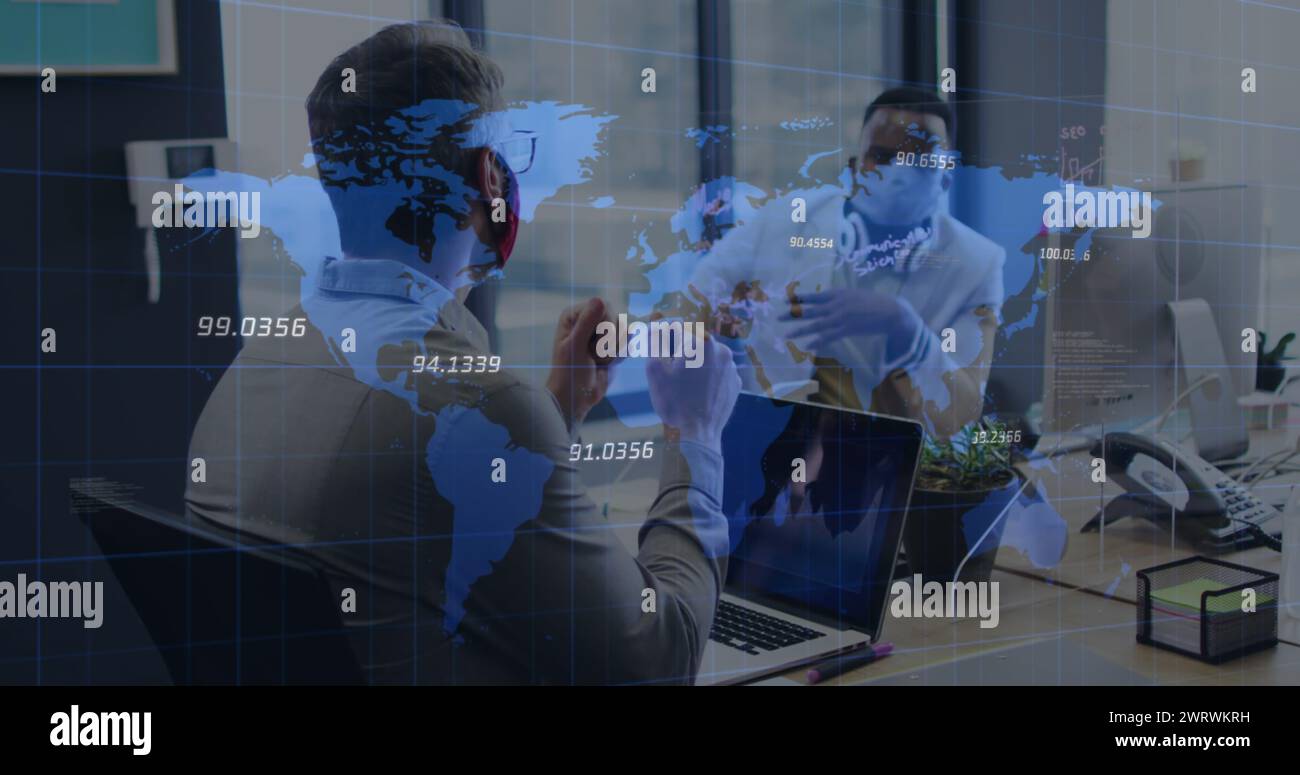 World map over two diverse male office colleagues wearing face masks ...