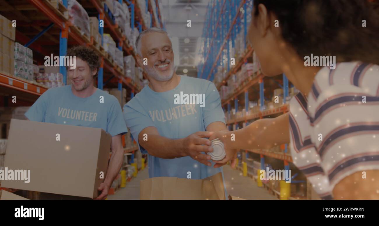 Image of glowing spots of light over diverse people carrying box ...