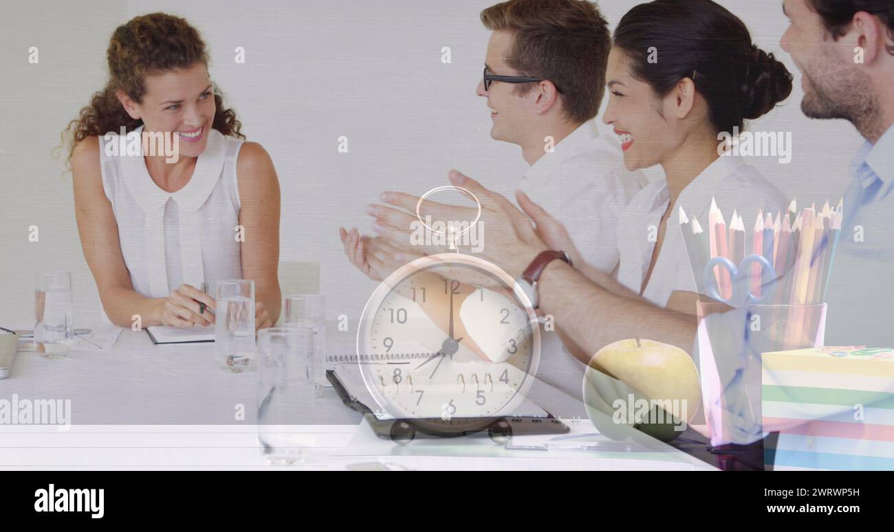 Image of clock over diverse business people talking Stock Photo - Alamy