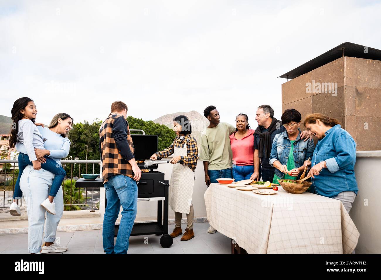 Multigenerational friends having fun doing barbecue at house rooftop ...