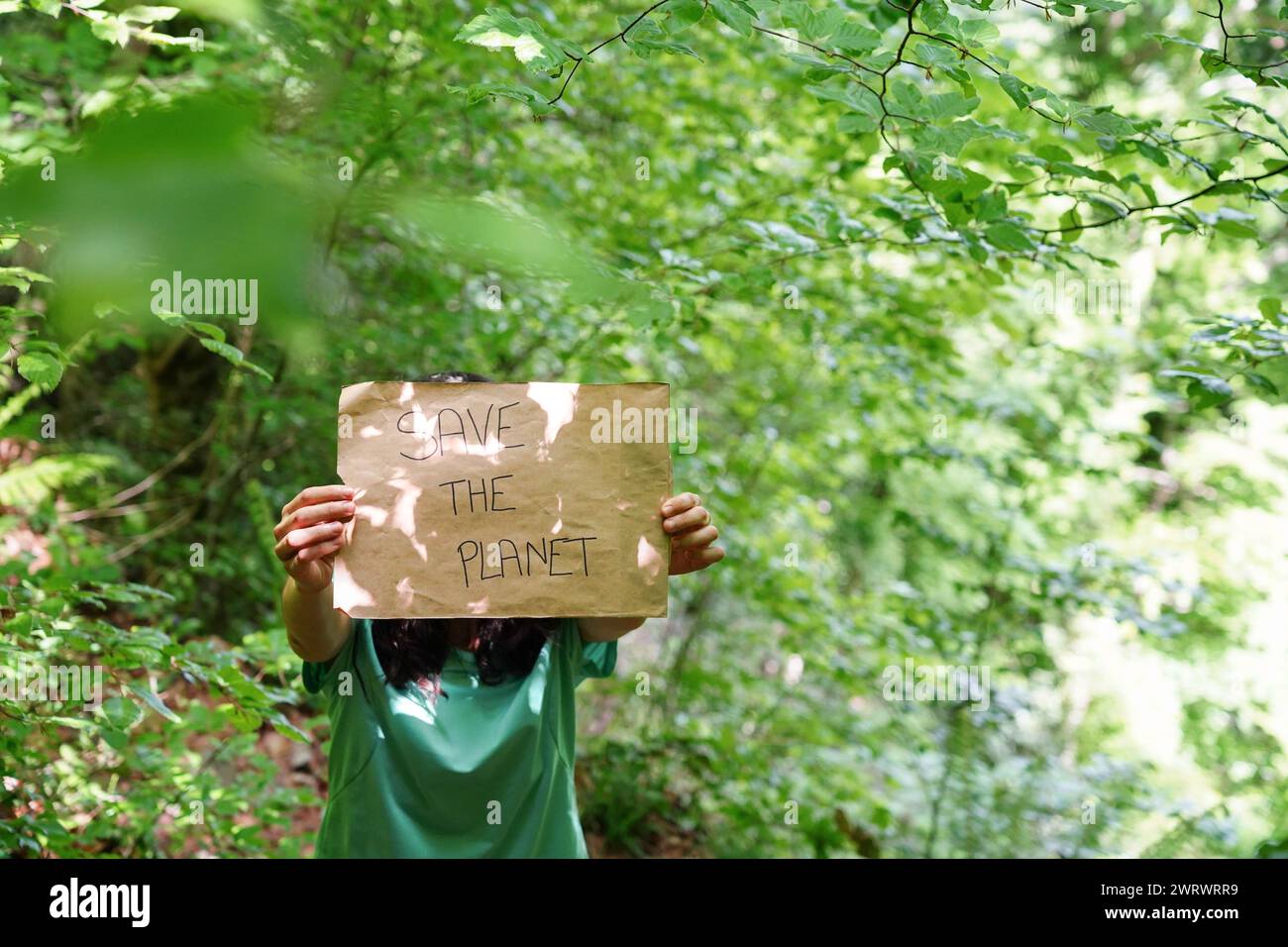 A person holding a sign that says "Save the Planet". Concept of urgency ...