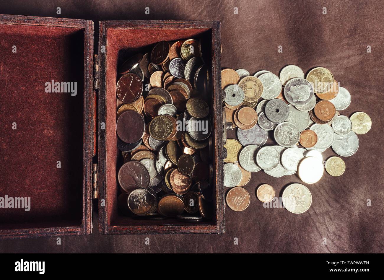 Photo of a wooden treasure box or chest filled with coins on table ...